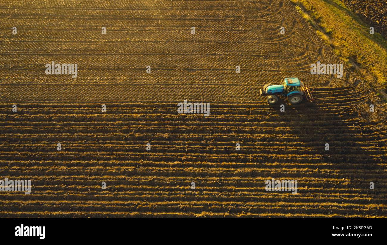 farmer with tractor leveling land in the countryside Stock Photo - Alamy
