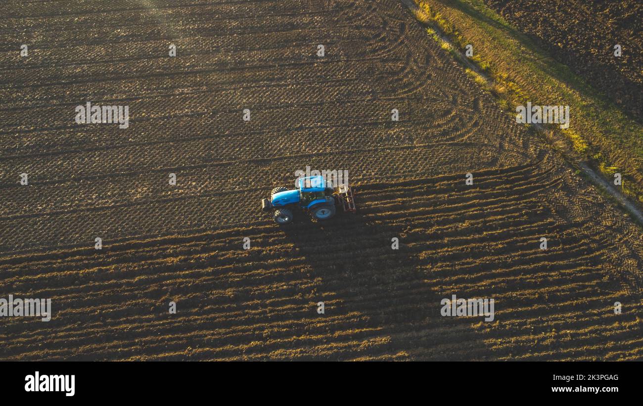 farmer with tractor leveling land in the countryside Stock Photo - Alamy