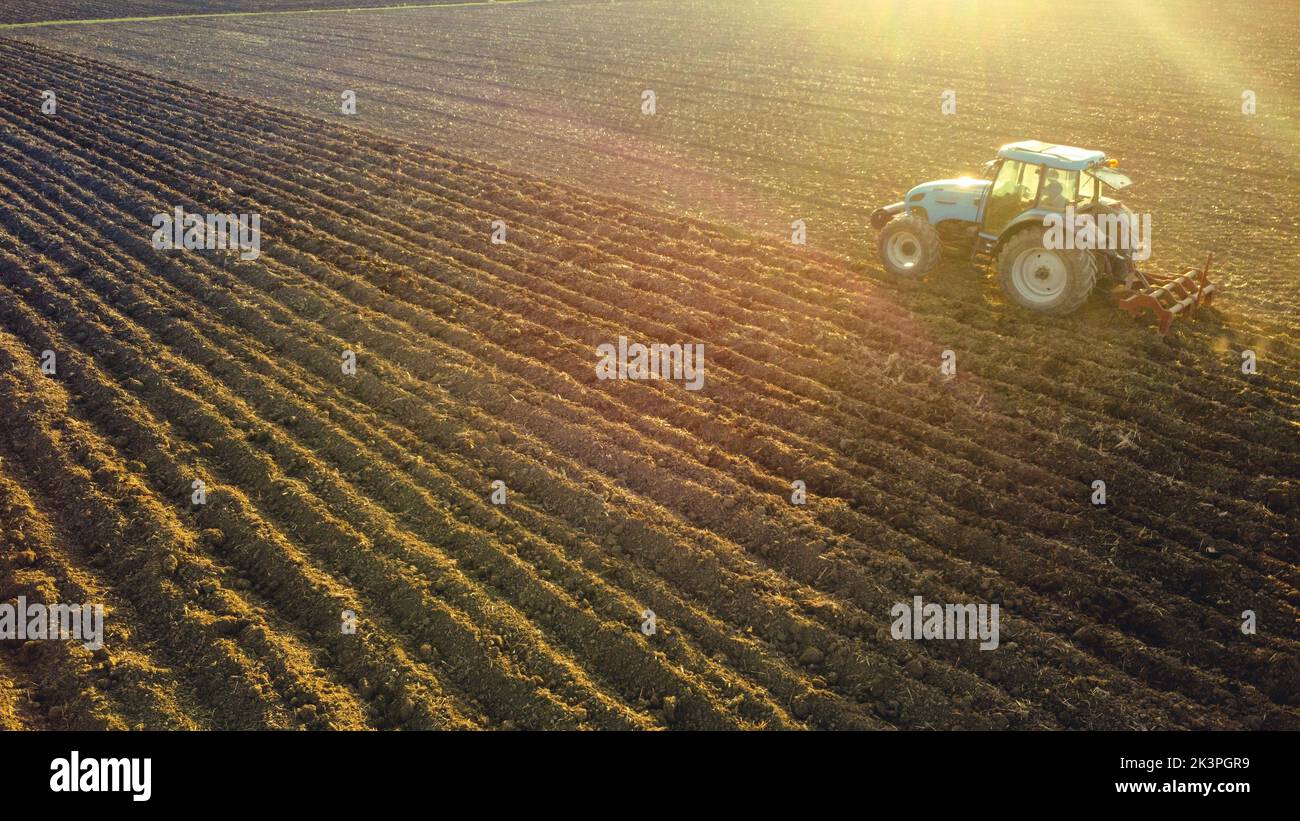 farmer with tractor leveling land in the countryside Stock Photo - Alamy