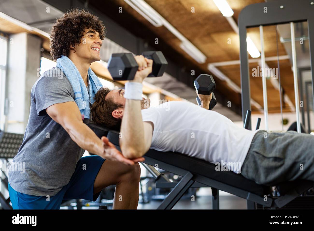 Fit man working out in gym with personal trainer to stay healthy. Sport ...