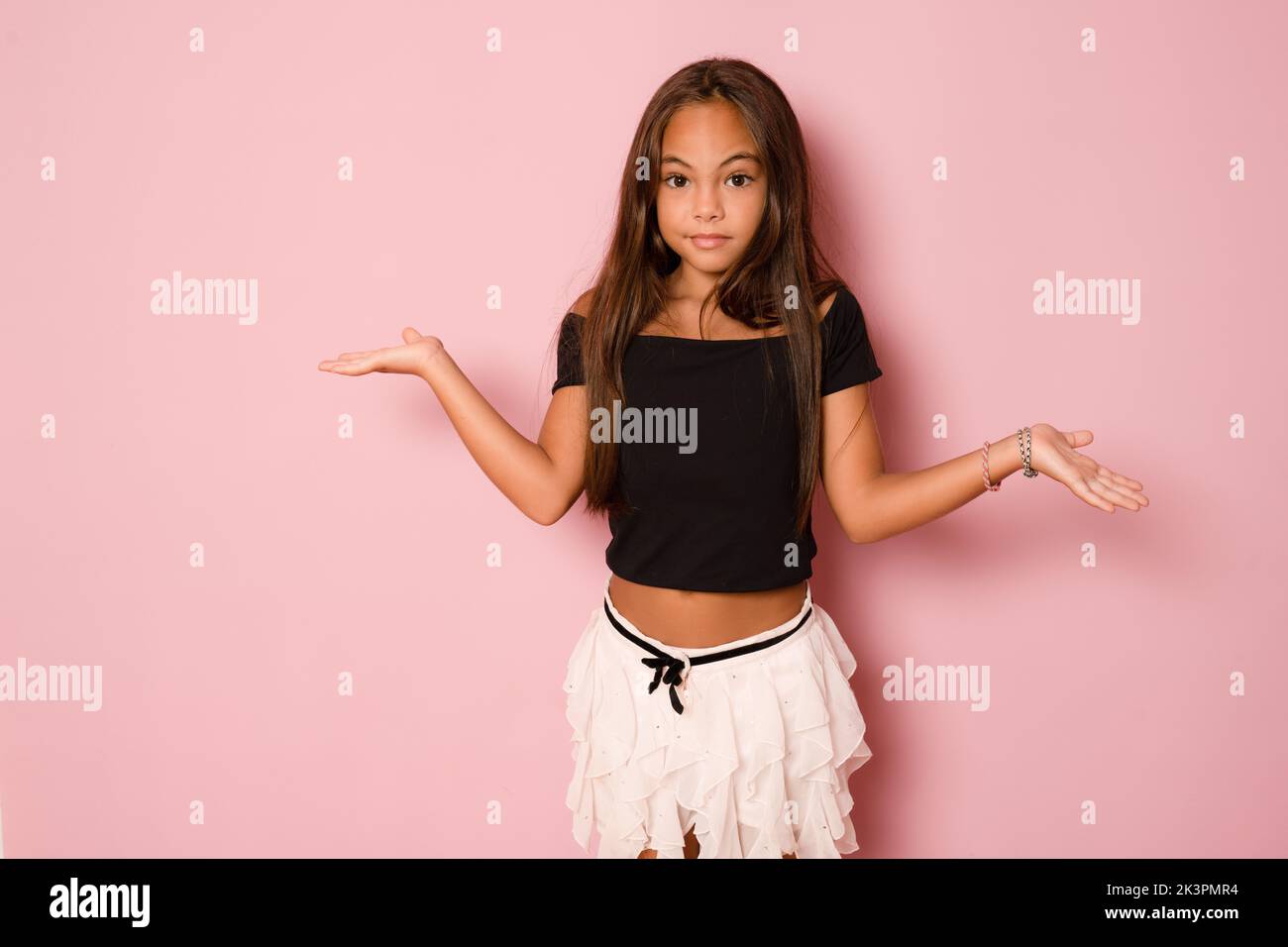 Cute little girl doubting and shrugging him shoulders in questioning ...