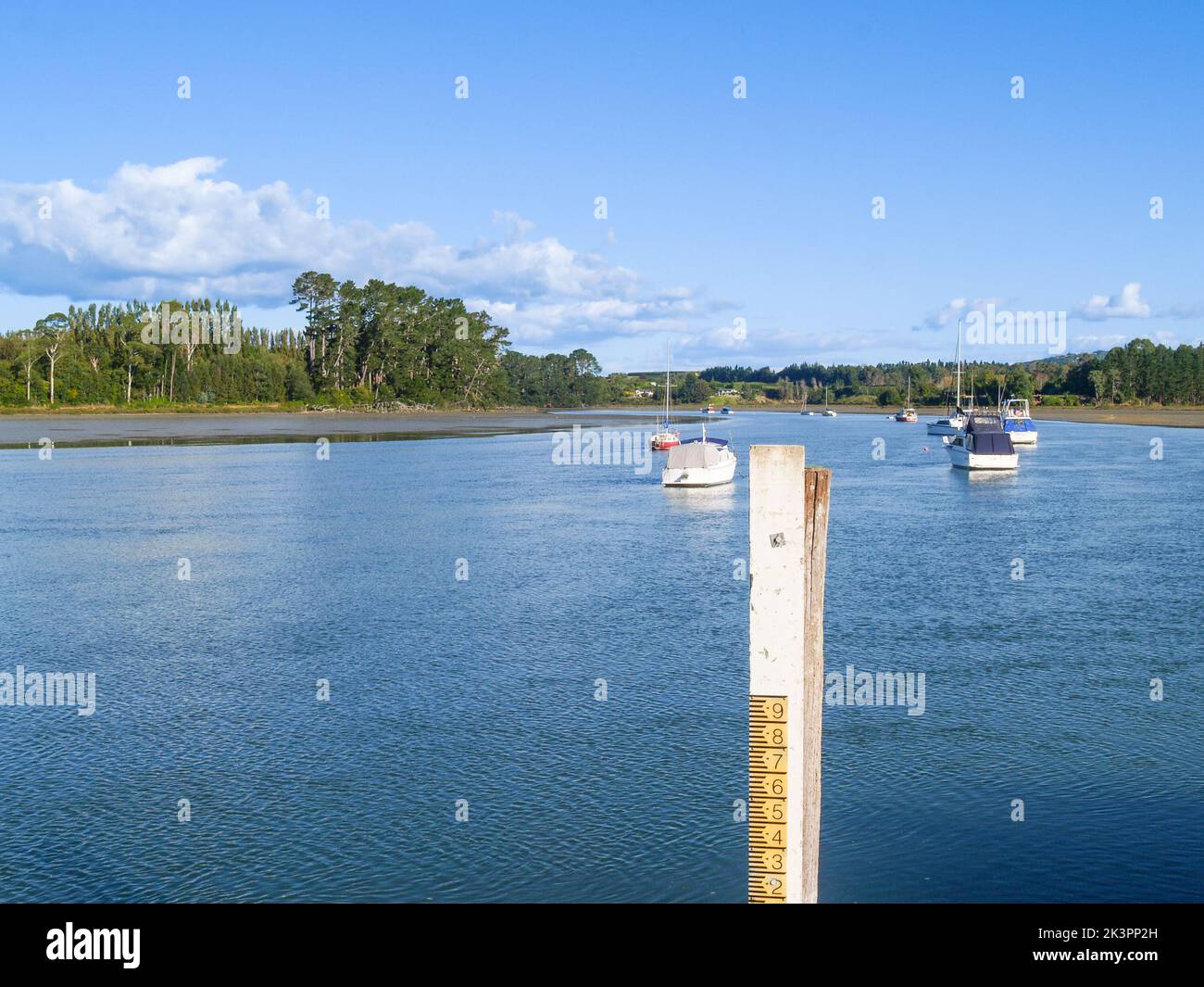 Sea tide depth measure in bay with moored boats leading up estuary at ...