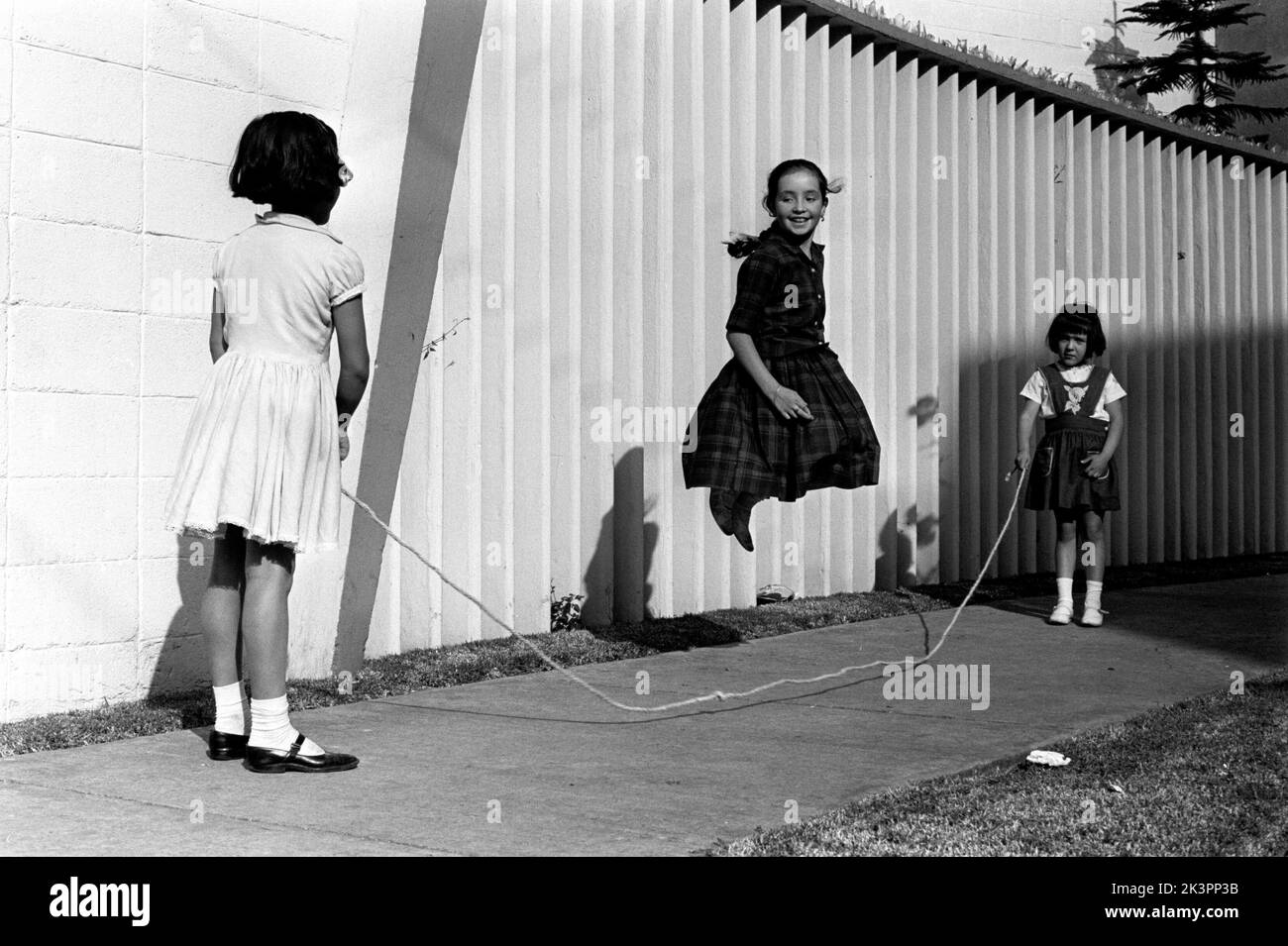 Mexico in the 1960s. Three girls are playing in the street, with a ...