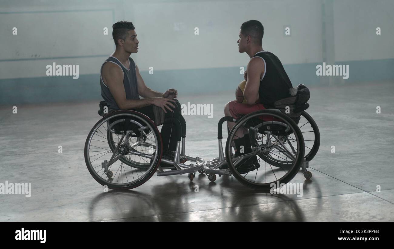 Two disabled athletes in conversation in wheelchairs. Handicapped ...