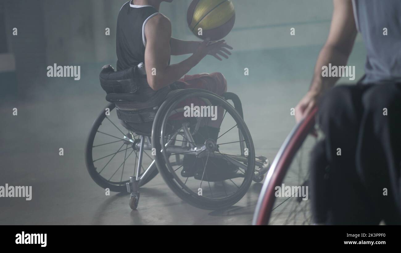 Two disabled athletes playing basketball. Handicapped athlete in ...