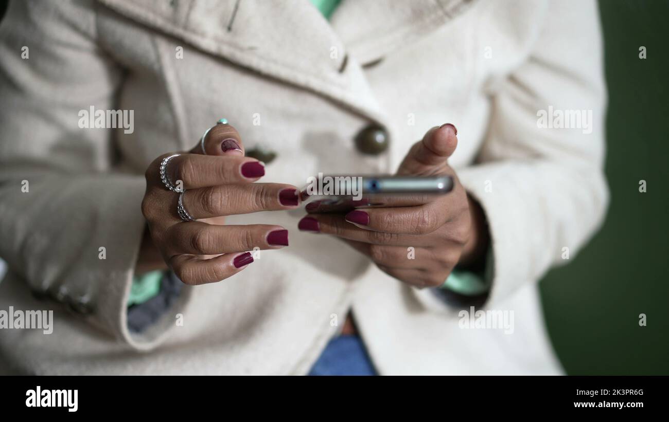 Closeup of a black woman hands holding cellphone device scrolling ...