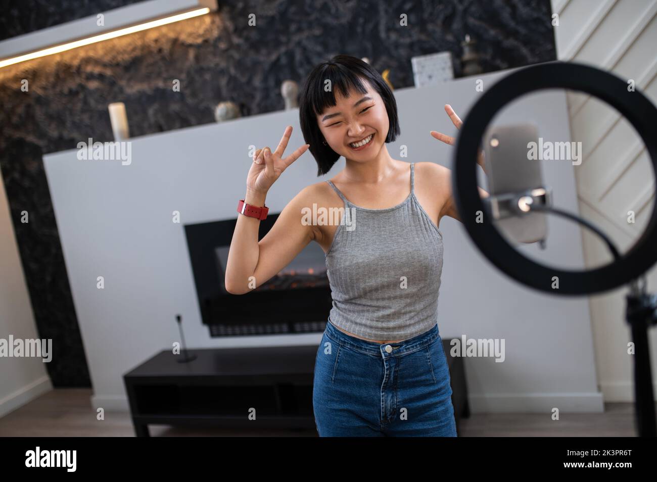 Joyous girl vlogger showing victory signs to her followers Stock Photo ...