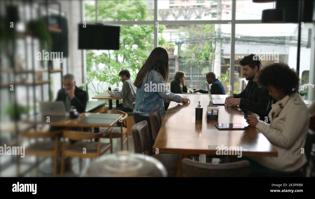 Customers inside coffee shop. Female friend bringing espresso to male ...