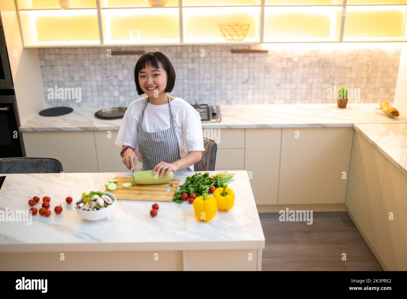 Cheerful female cook slicing the summer squash Stock Photo - Alamy
