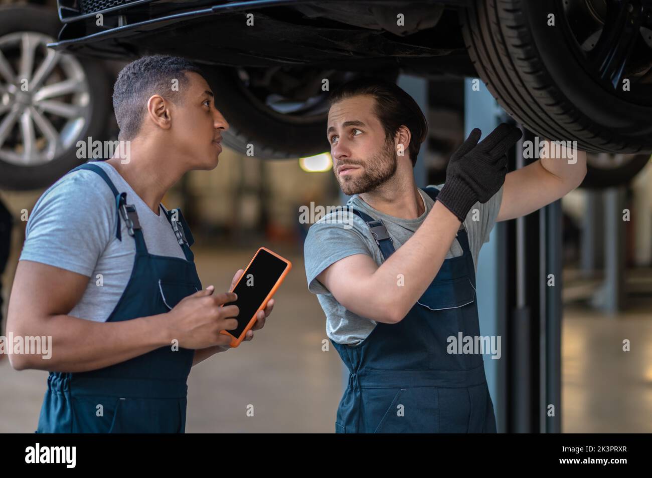 Skilled mechanics checking tires on the customer vehicle Stock Photo ...