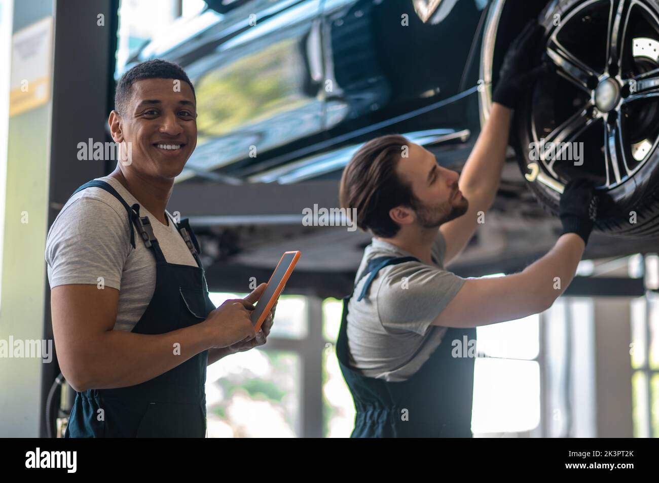 Automotive repair shop workers fixing the vehicle Stock Photo - Alamy