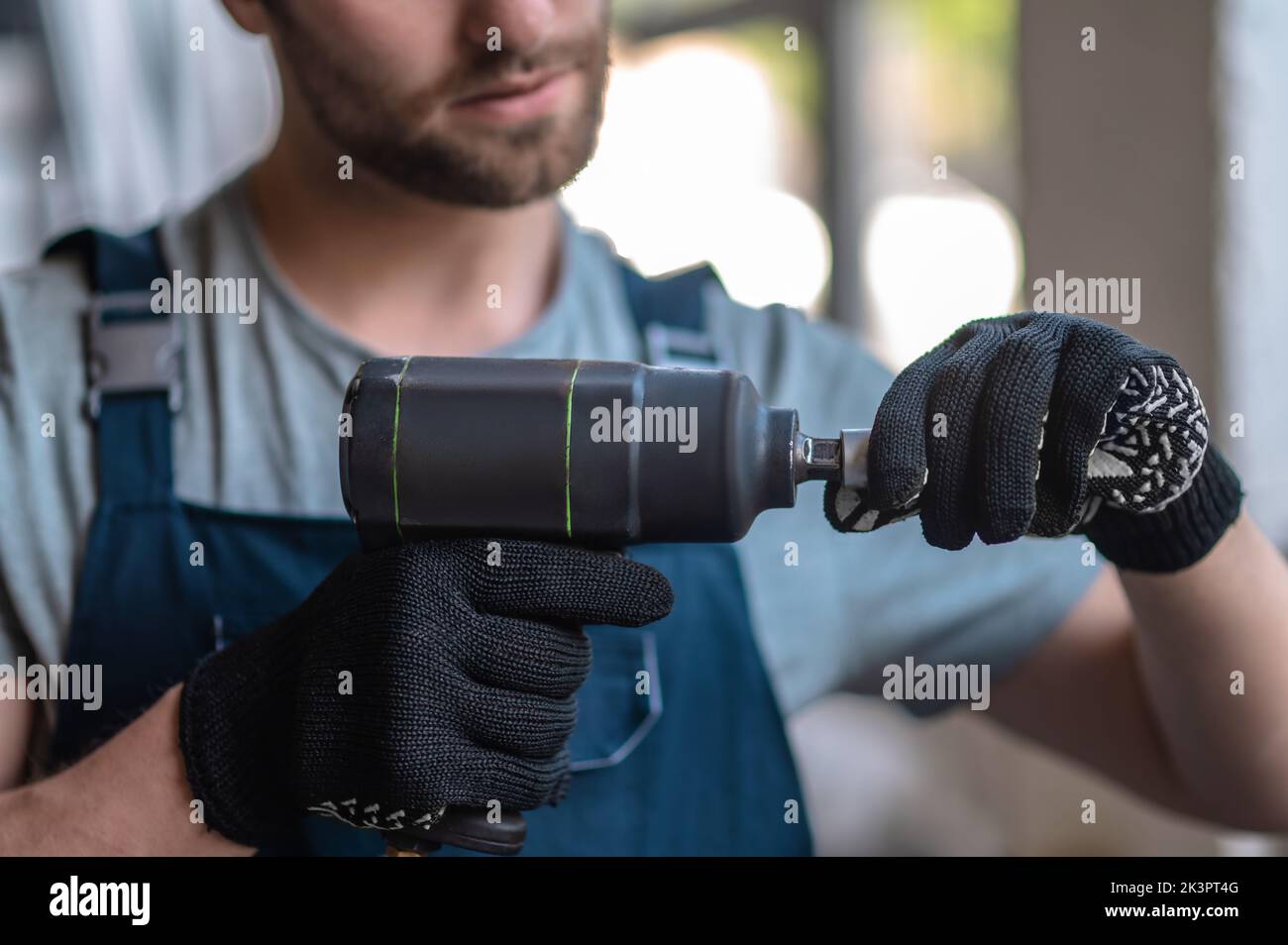 Skilled male worker using a work tool Stock Photo - Alamy
