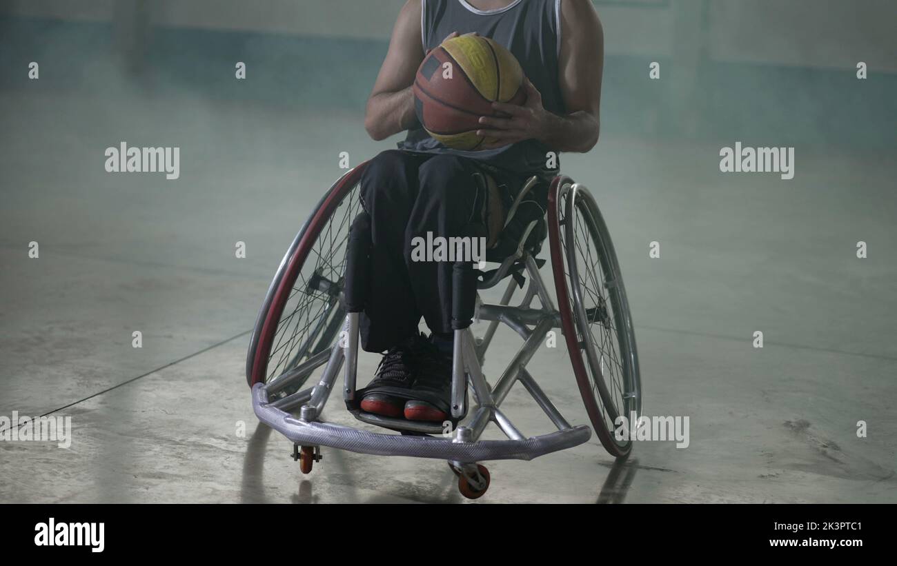 A disabled athlete in wheelchair holding basketball. Handicapped ...