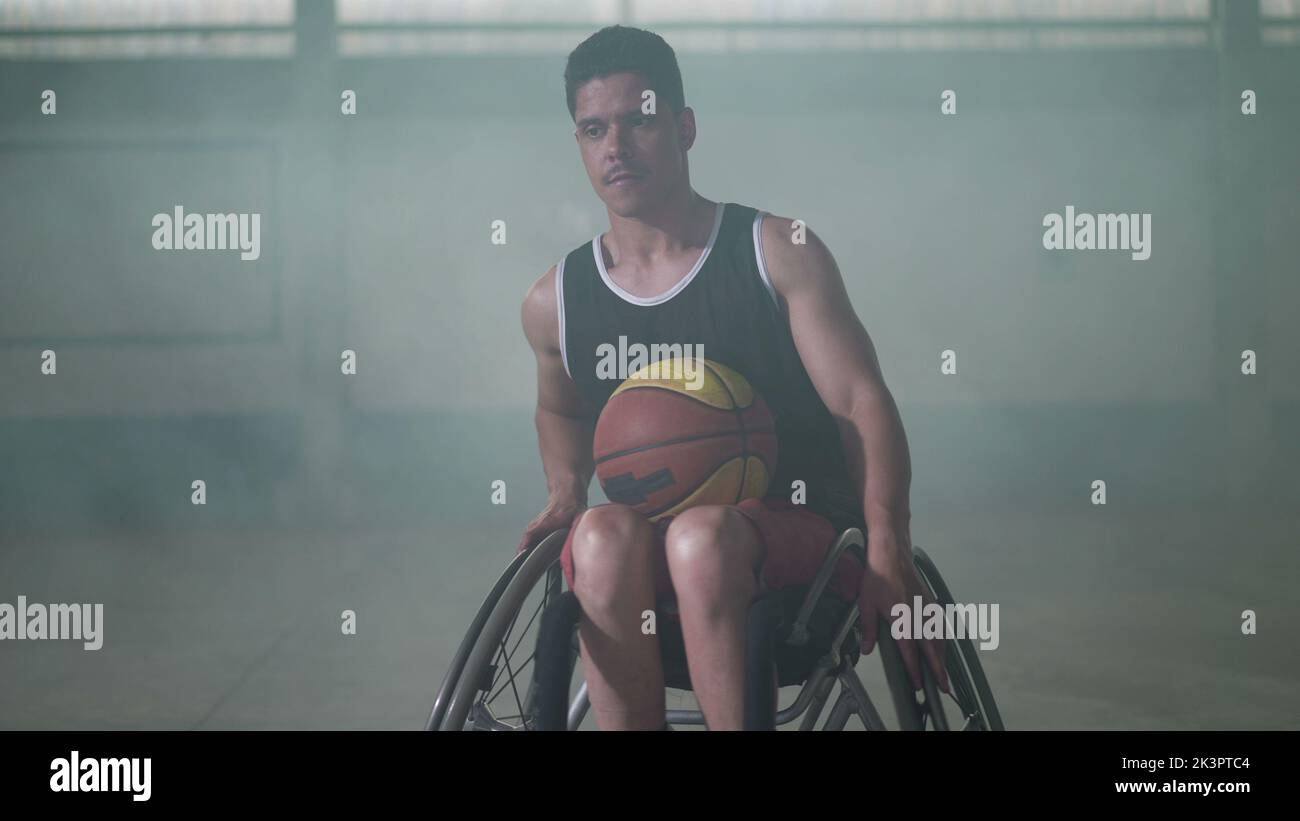 A disabled athlete in wheelchair holding basketball. Handicapped ...