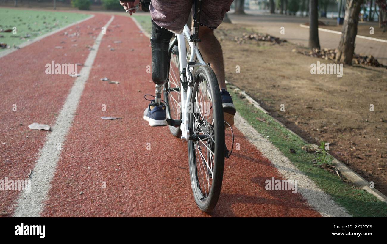 A disabled amputee cyclist riding bicycle with prosthetic leg Stock ...