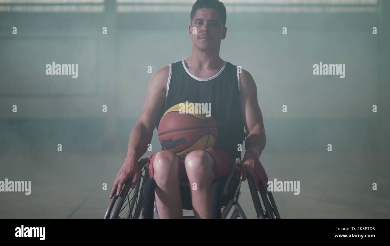A disabled athlete in wheelchair holding basketball. Handicapped ...