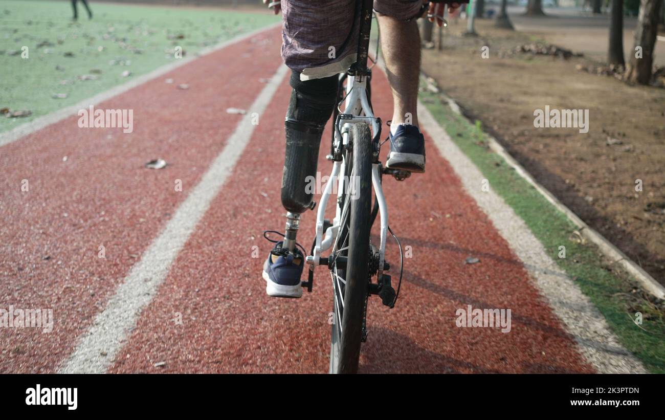 A disabled amputee cyclist riding bicycle with prosthetic leg Stock ...