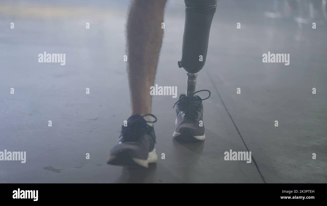 A disabled middle aged man walking with his prosthetic leg indoors ...