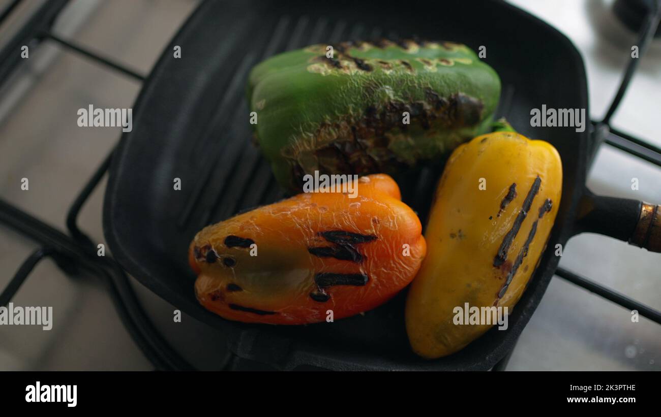 Cooking peppers on pan. Roasting red green and yellow peppers Stock ...