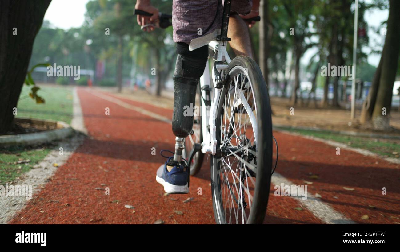 Disabled person riding bicycle using prosthetic leg outdoors Stock ...