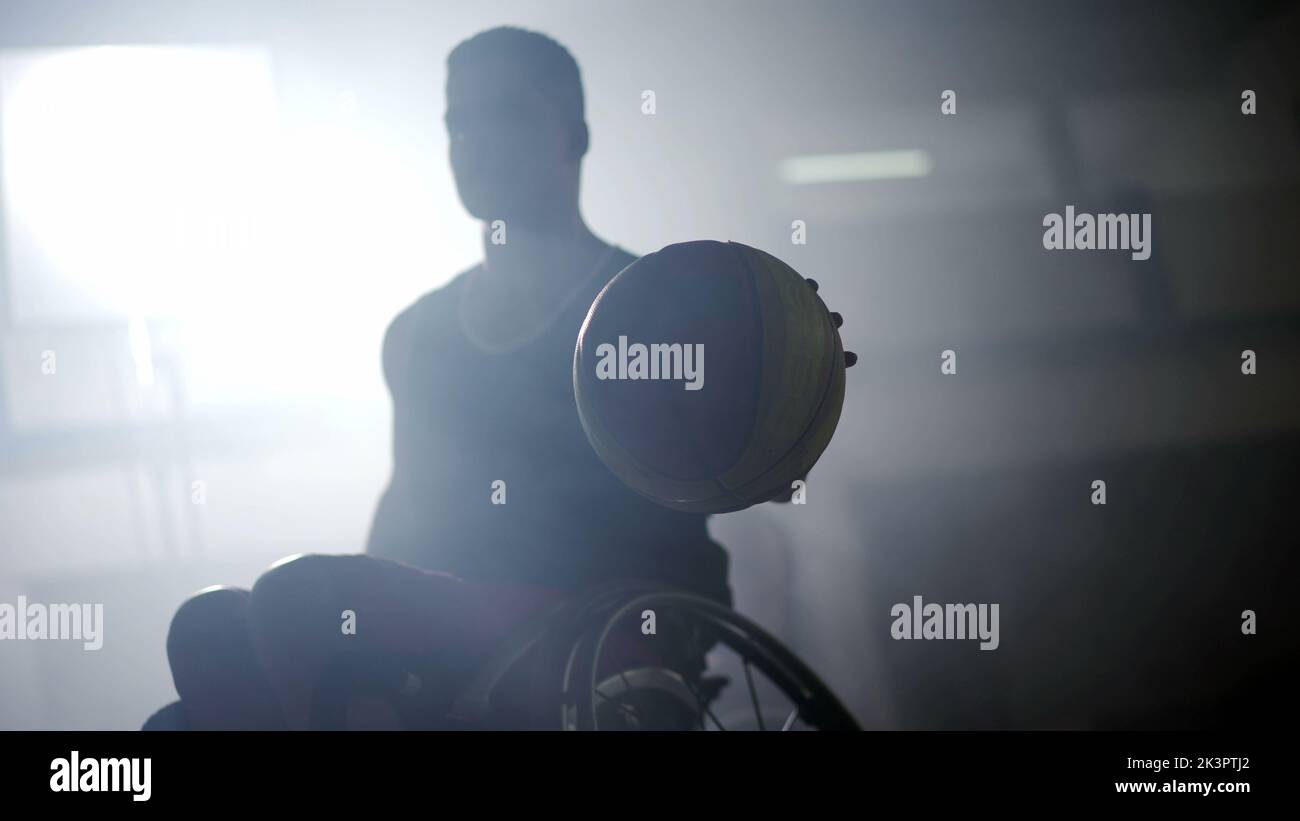 Disabled basketball player in wheelchair with dramatic lighting ...