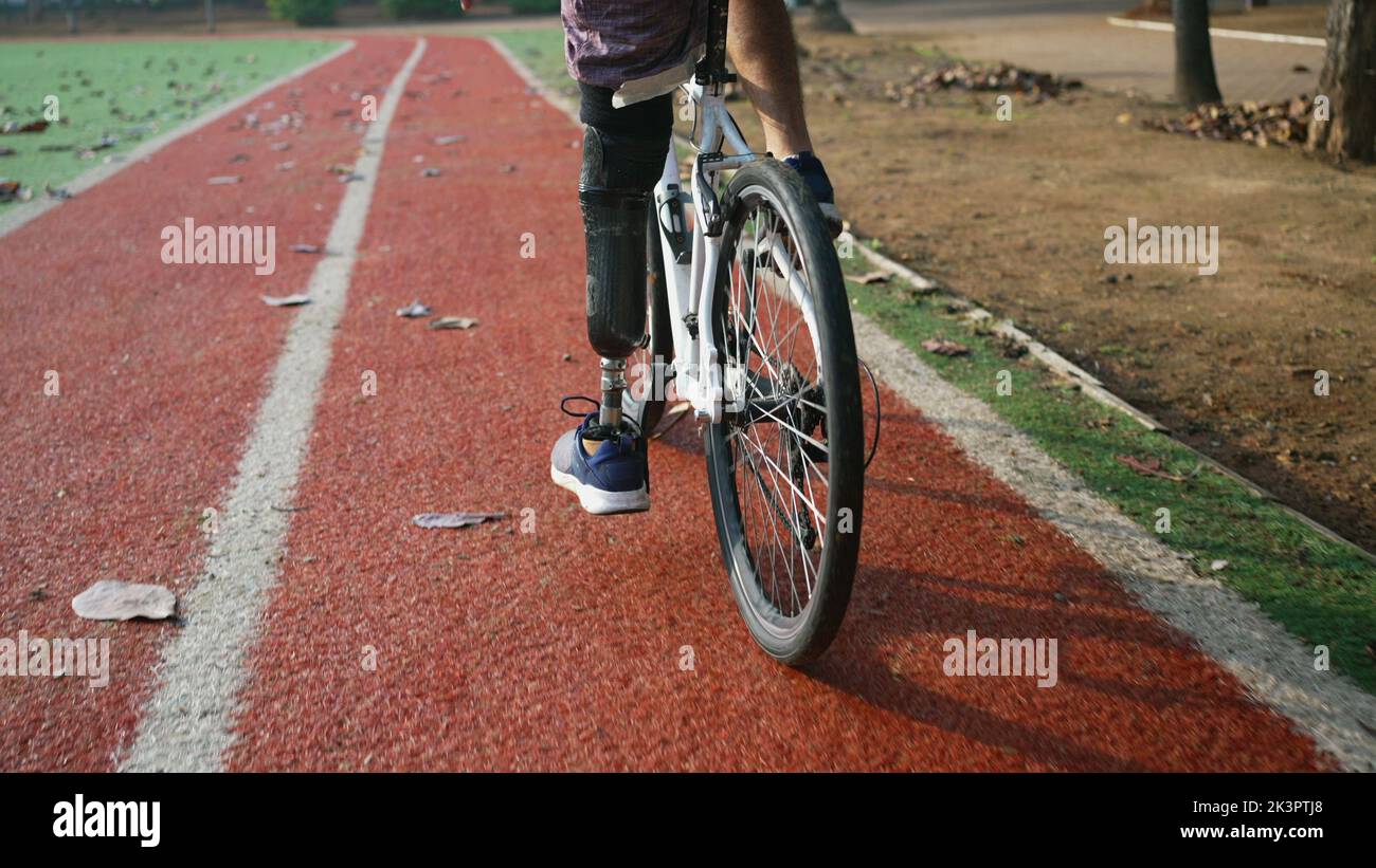 Disabled person riding bicycle with prosthetic leg Stock Photo - Alamy