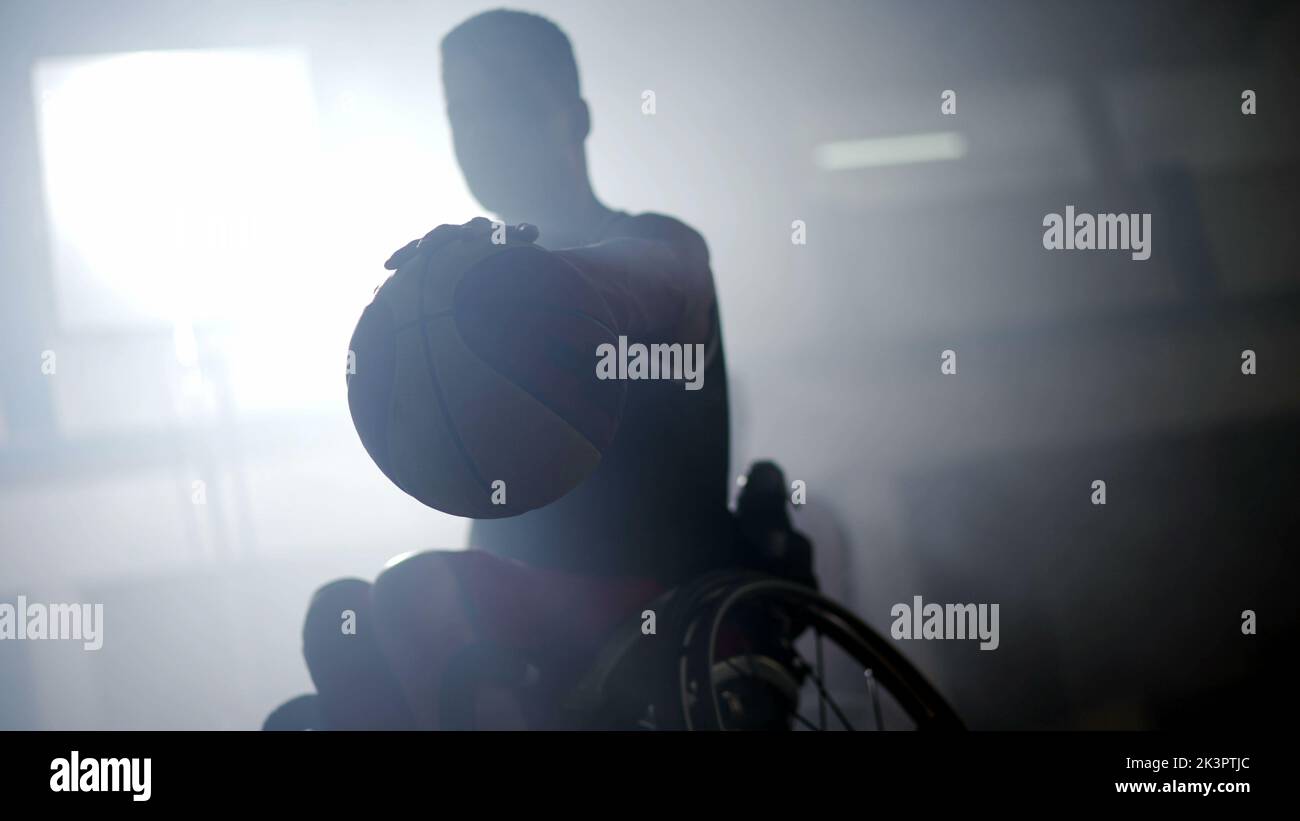 Disabled basketball player in wheelchair with dramatic lighting ...