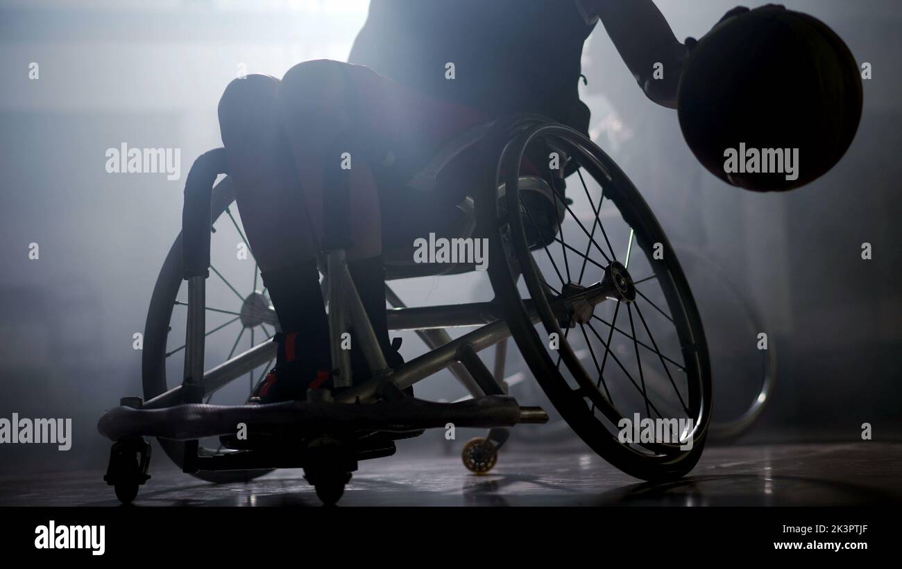 Disabled basketball player in wheelchair with dramatic lighting ...