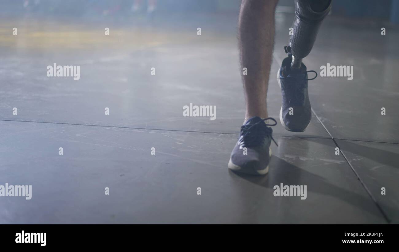 Disabled person walking with his prosthetic leg indoors. Amputee man ...