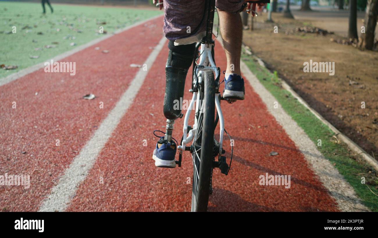 Disabled person riding bicycle with prosthetic leg Stock Photo - Alamy
