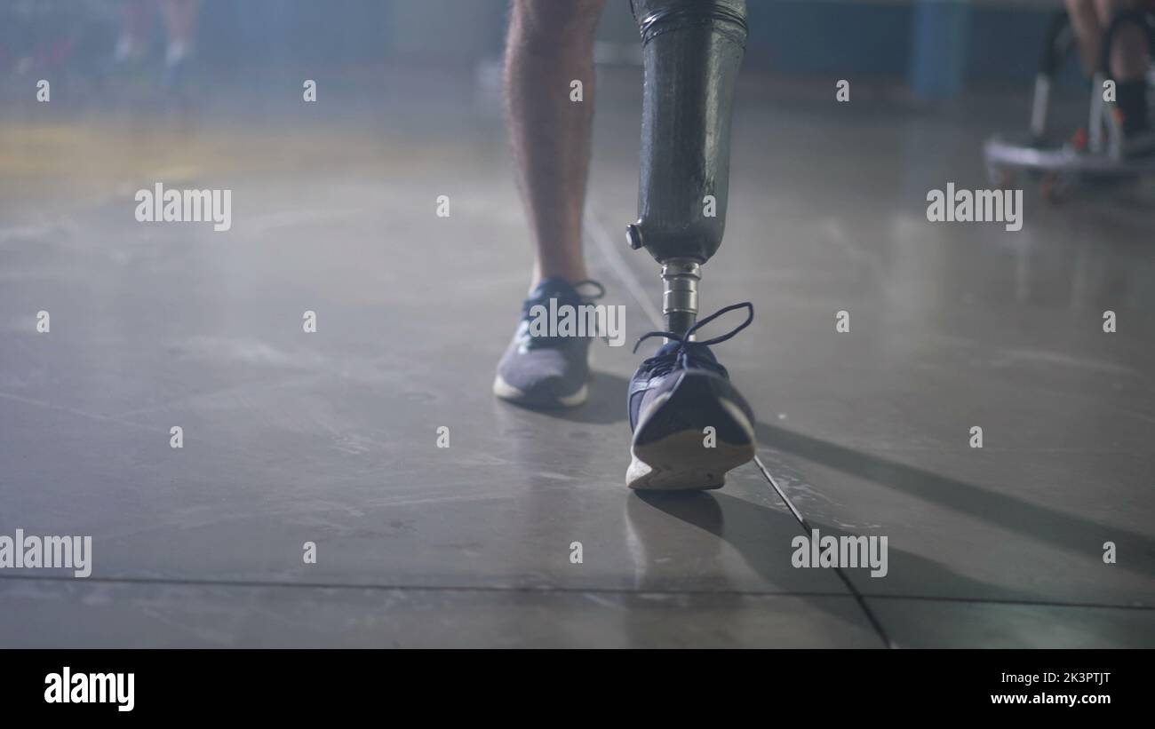 Disabled person walking with his prosthetic leg indoors. Amputee man ...