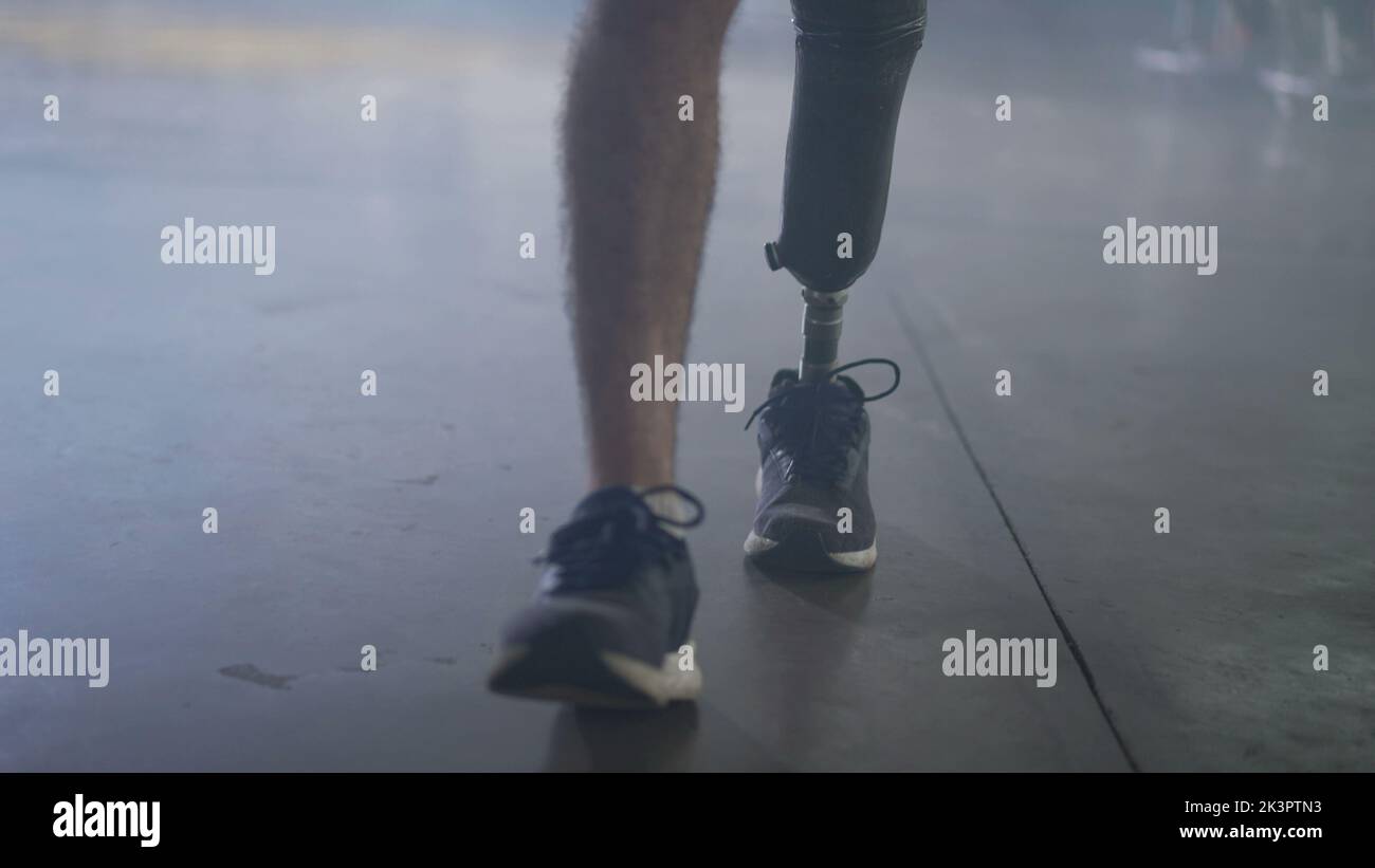 Disabled person walking with his prosthetic leg indoors. Amputee man ...