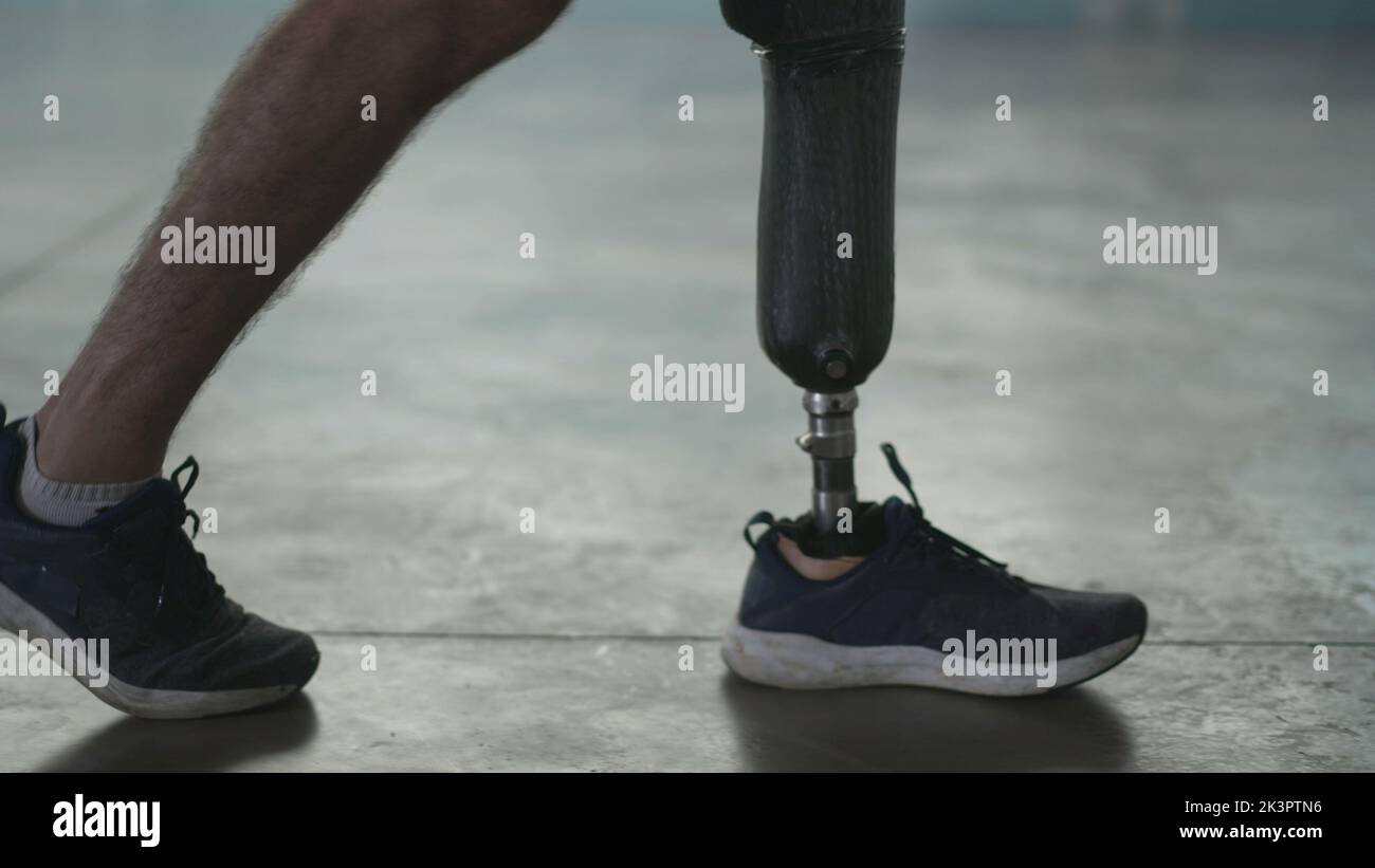 Disabled person walking with his prosthetic leg indoors. Amputee man ...