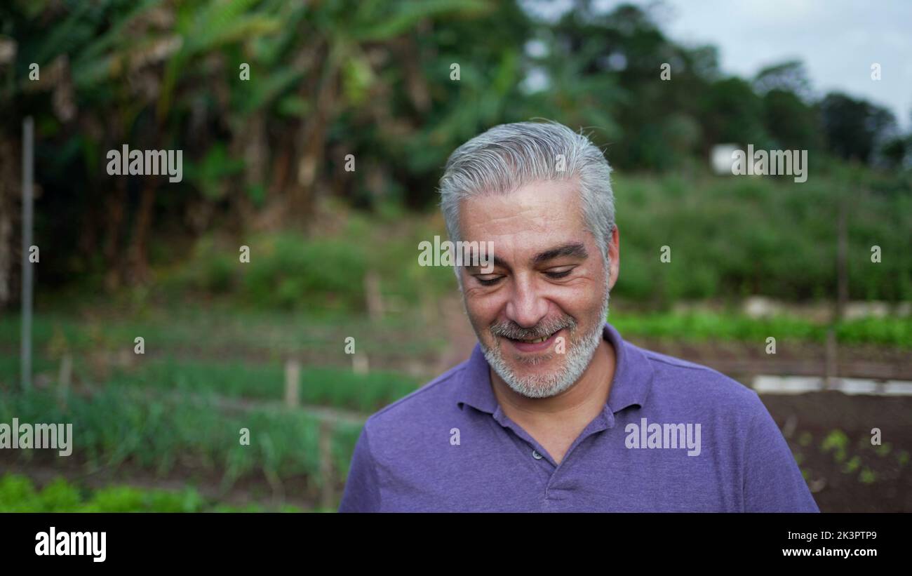 Happy older man walking forward in farm. Senior person portrait face at ...