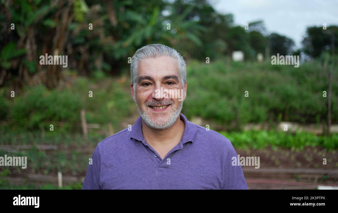 Happy older man walking forward in farm. Senior person portrait face at ...