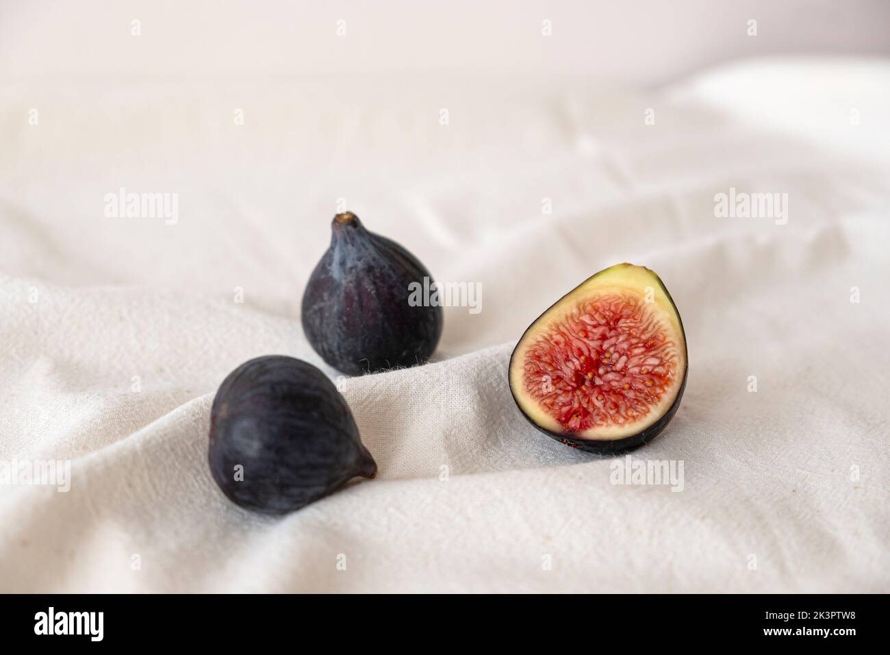Fresh ripe and sweet figs halved on beige color table cloth Stock Photo ...