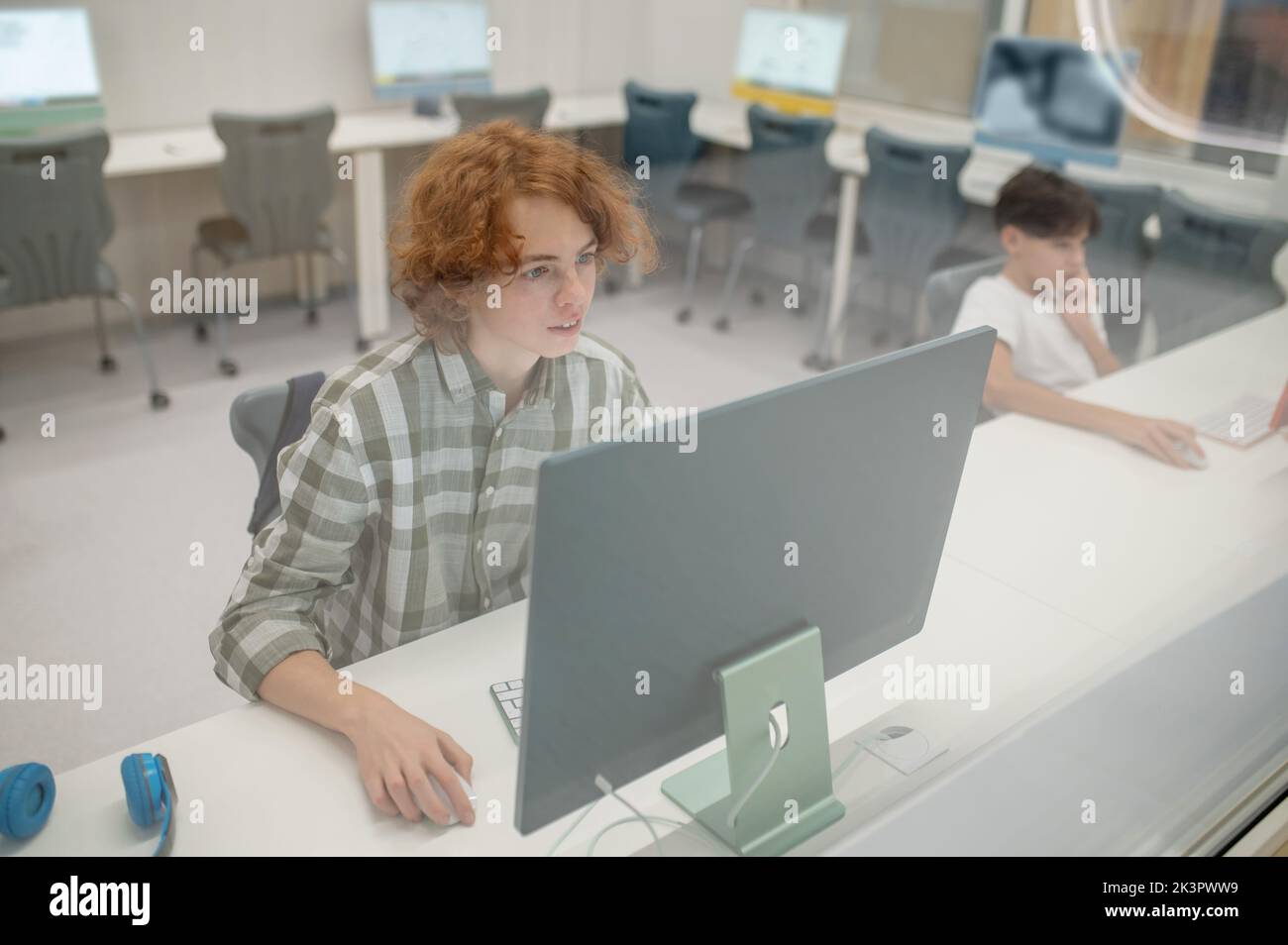 Ginger school boy working on a computer in computer classroom Stock Photo - Alamy