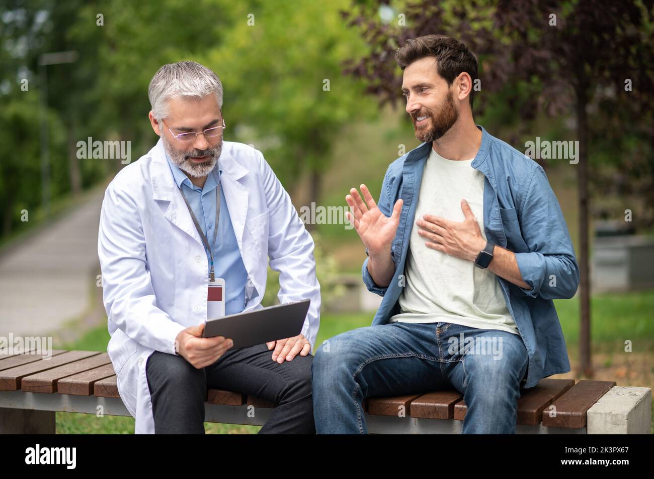 Male patient talking to his doctor and telling about symptoms Stock ...