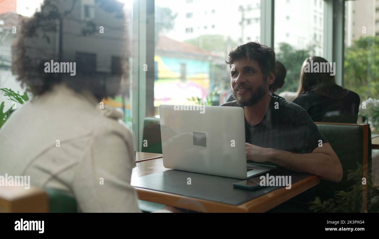 People inside coffee shop through glass window. Men and women customers ...