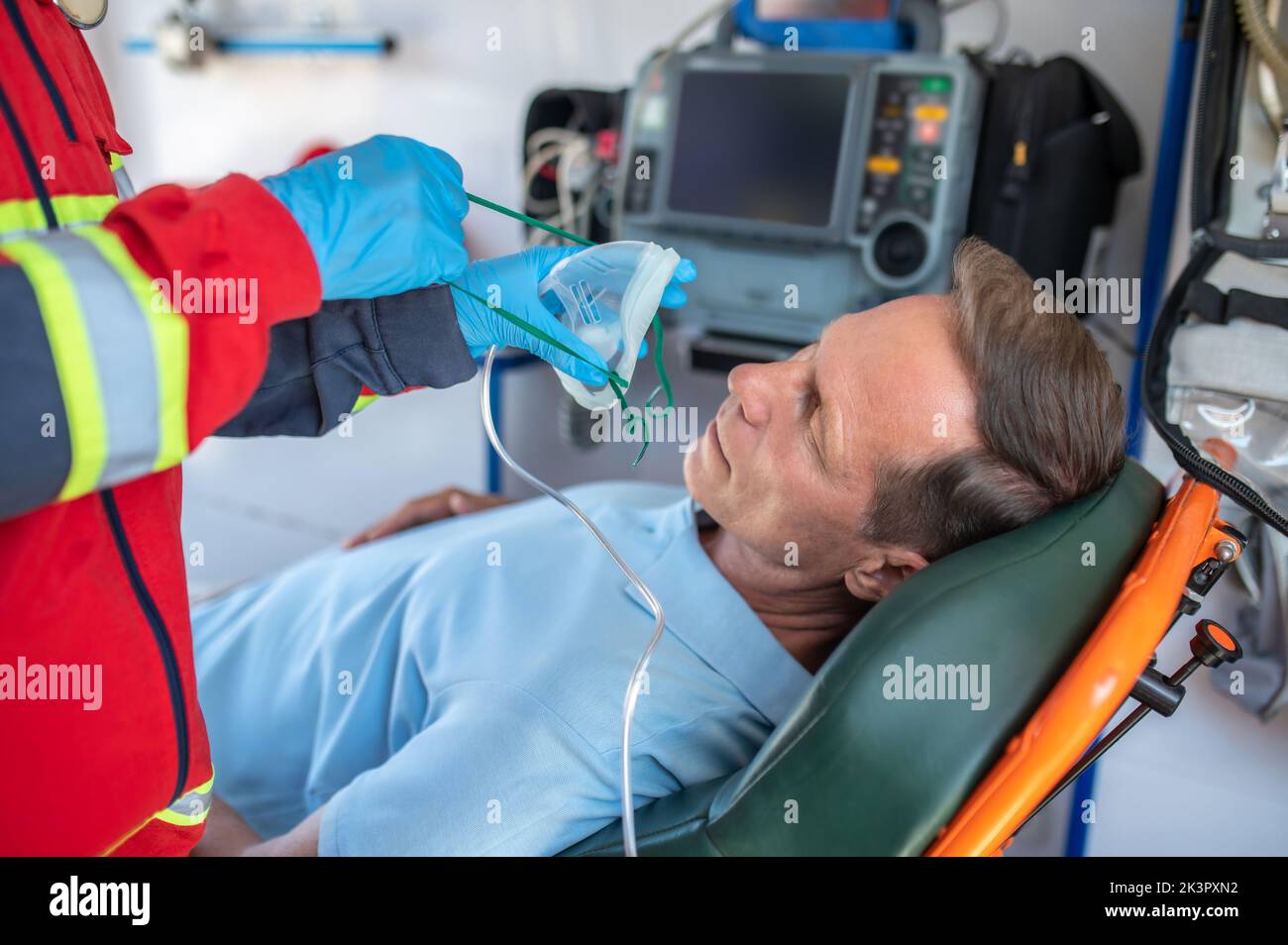 Paramedic preparing an unconscious man for oxygen therapy Stock Photo ...