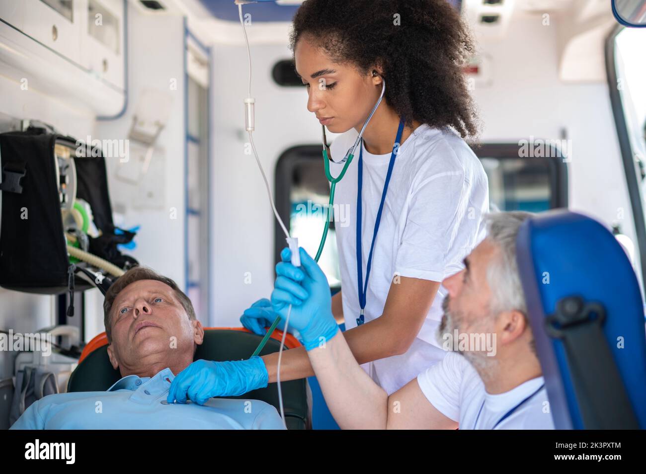 Paramedical staff providing emergency medical care to an ill man Stock ...