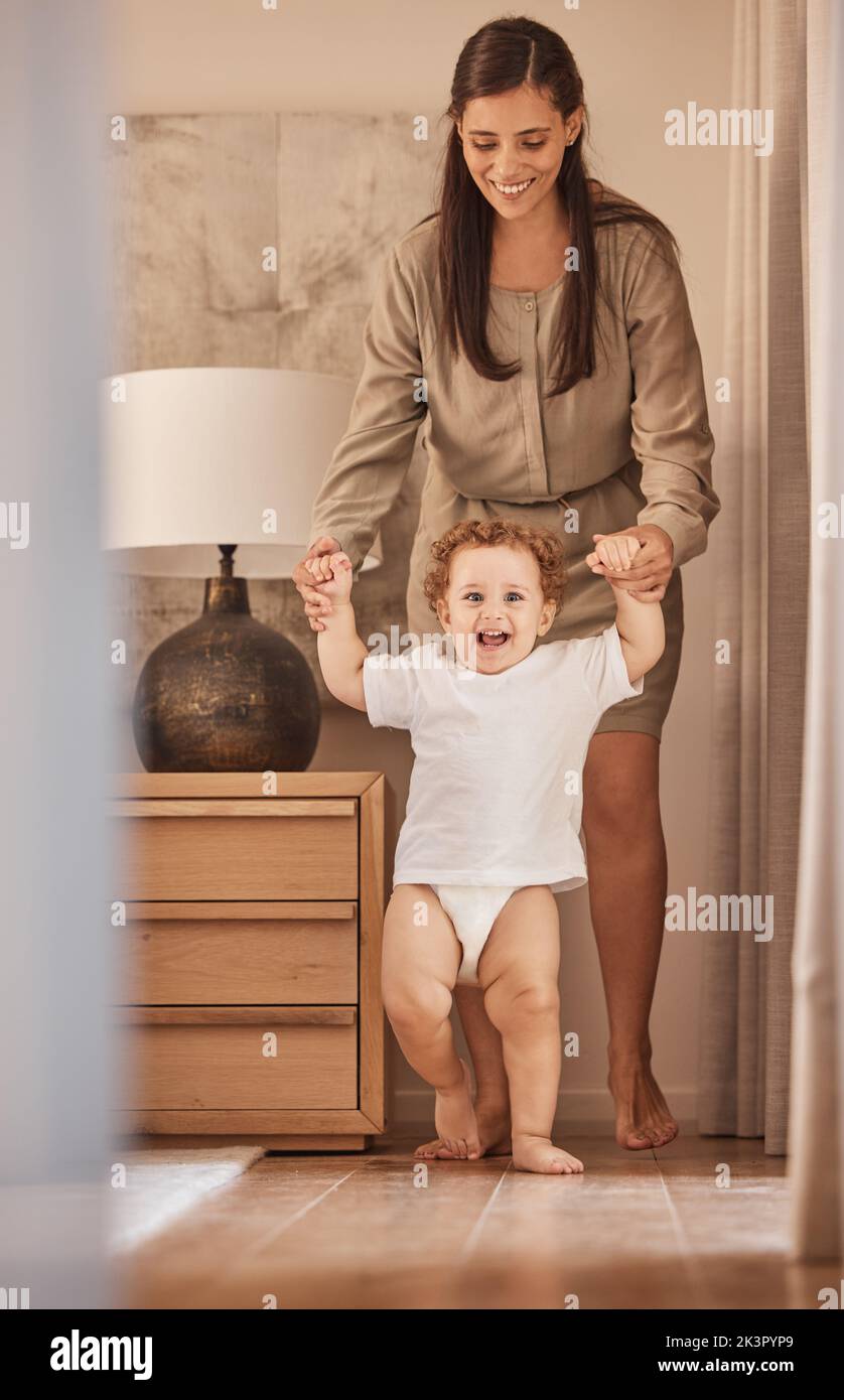 Love, mother and baby learning to walk while holding hands for support ...