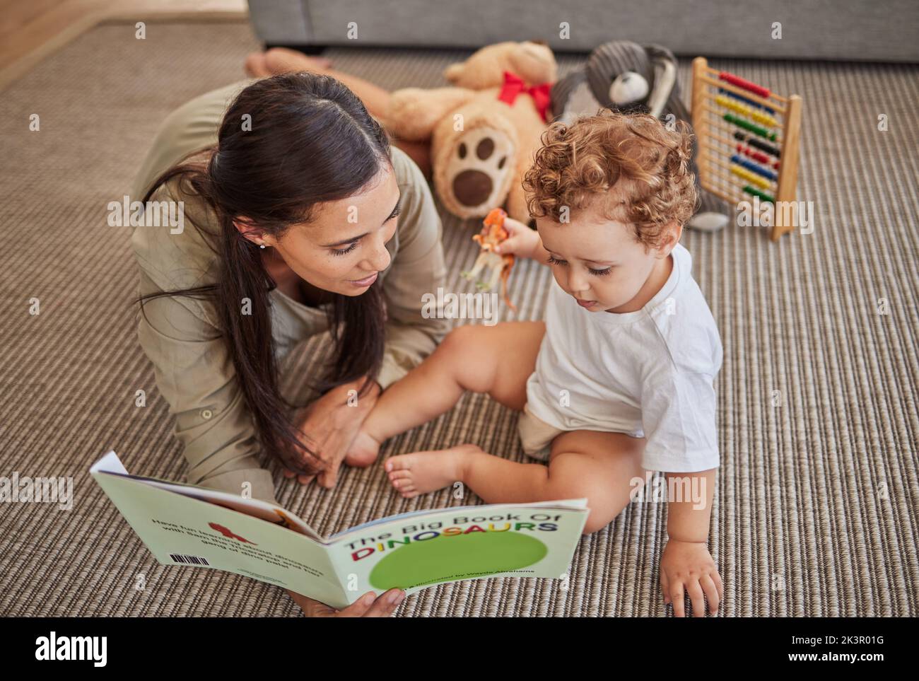 Mother, baby and book for story for education on carpet in home, for ...