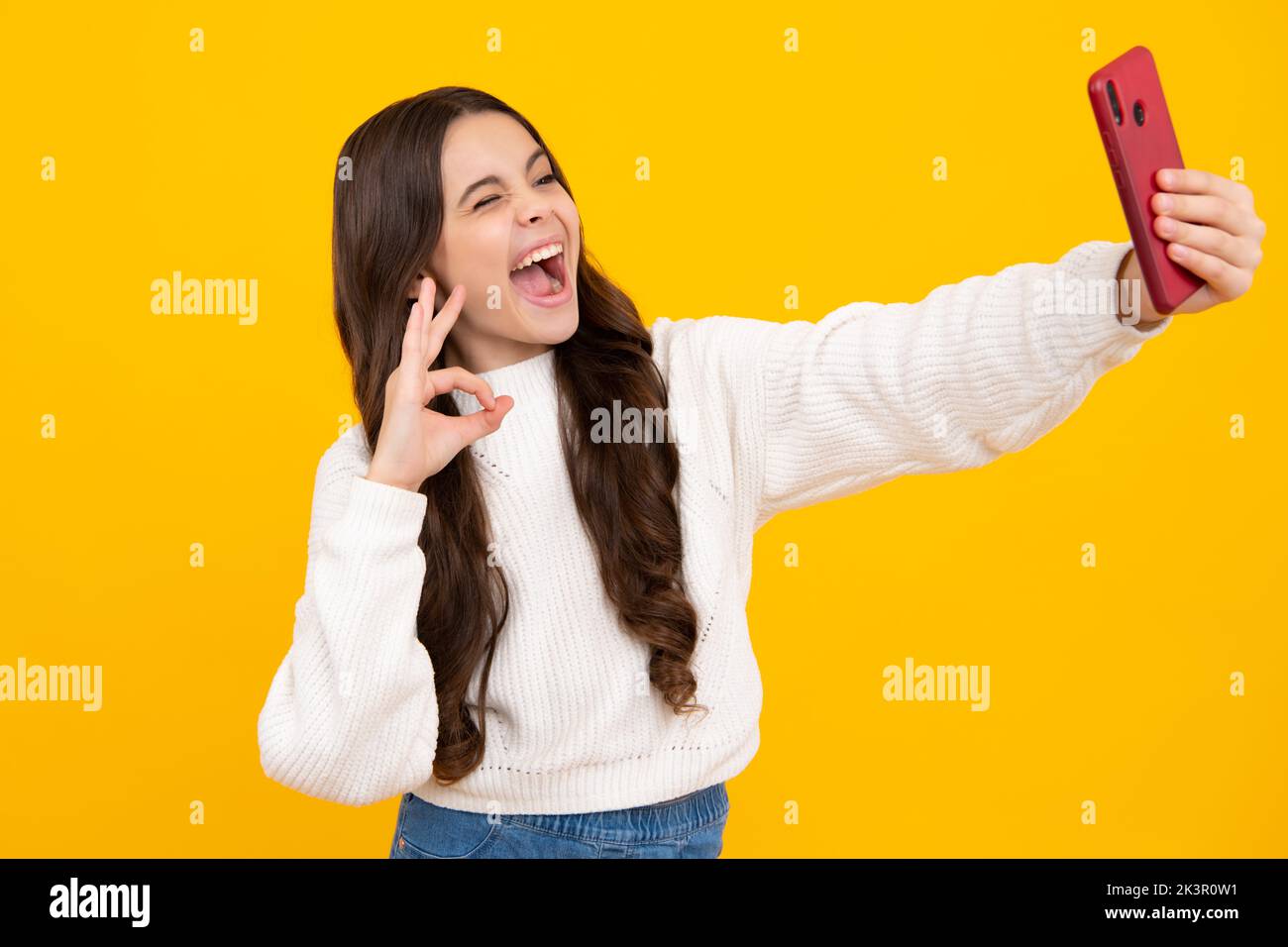 Excited teenager girl. Portrait of cute teenage girl using mobile phone ...
