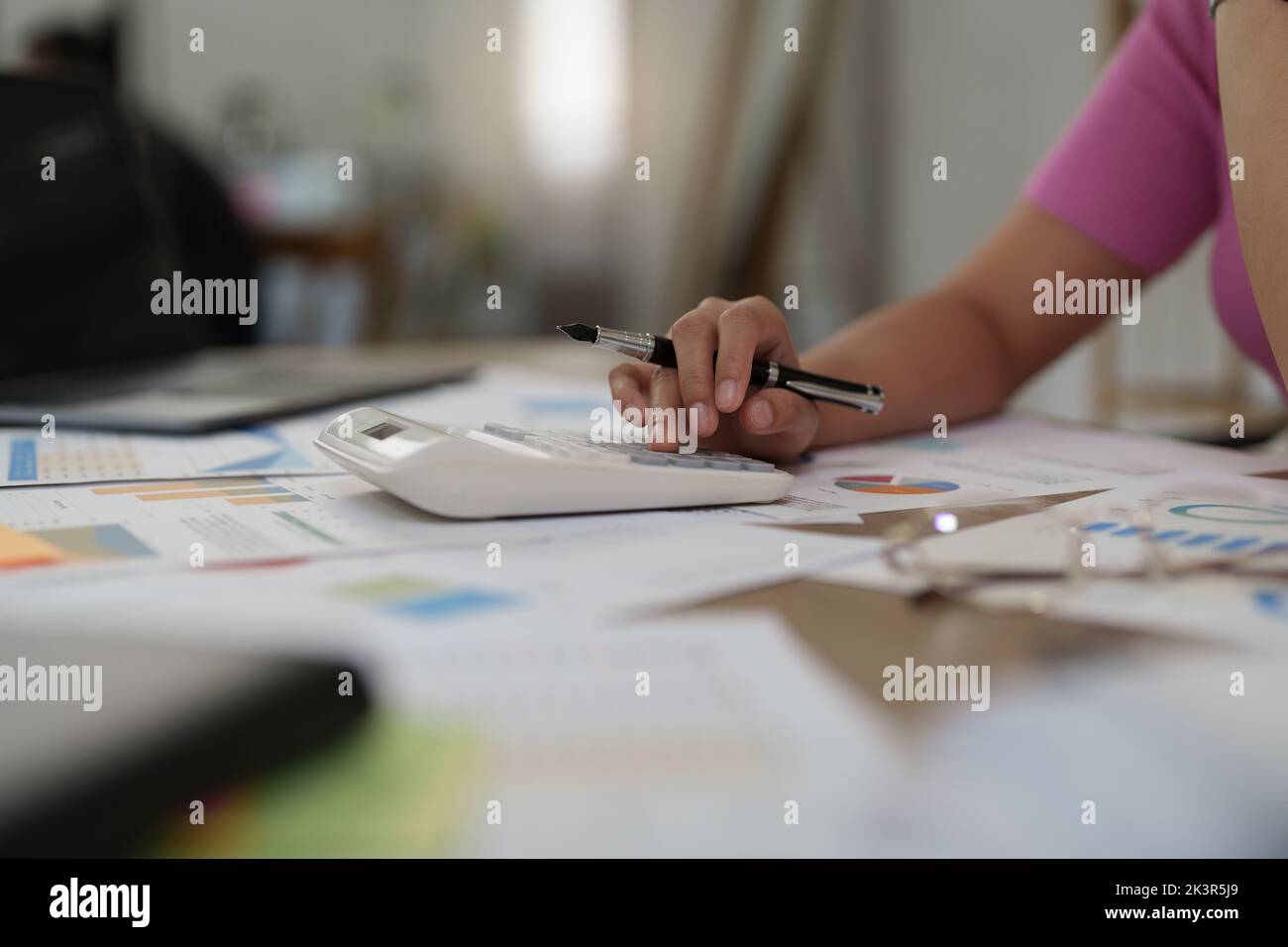 Asian Businesswoman calculating saving account balance with calculator ...