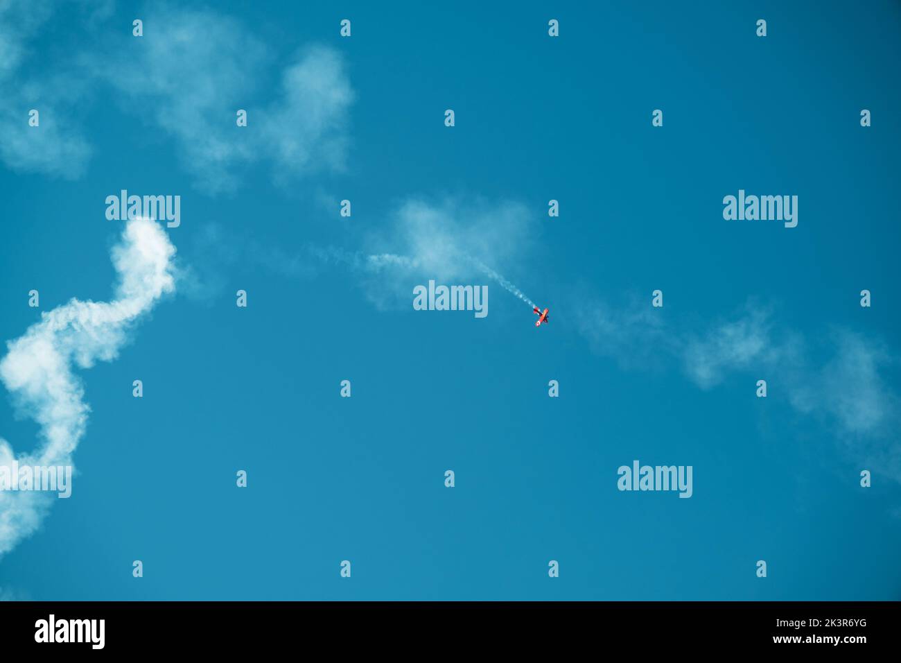 Smoke of an acrobatic plane on the blue sky Stock Photo - Alamy