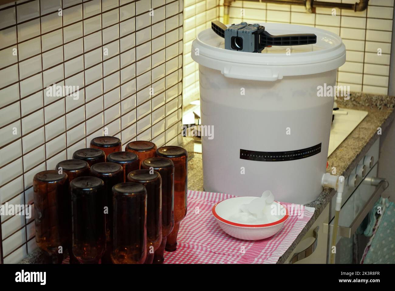The process of beer brewing in the kitchen at home with beer bottles ...