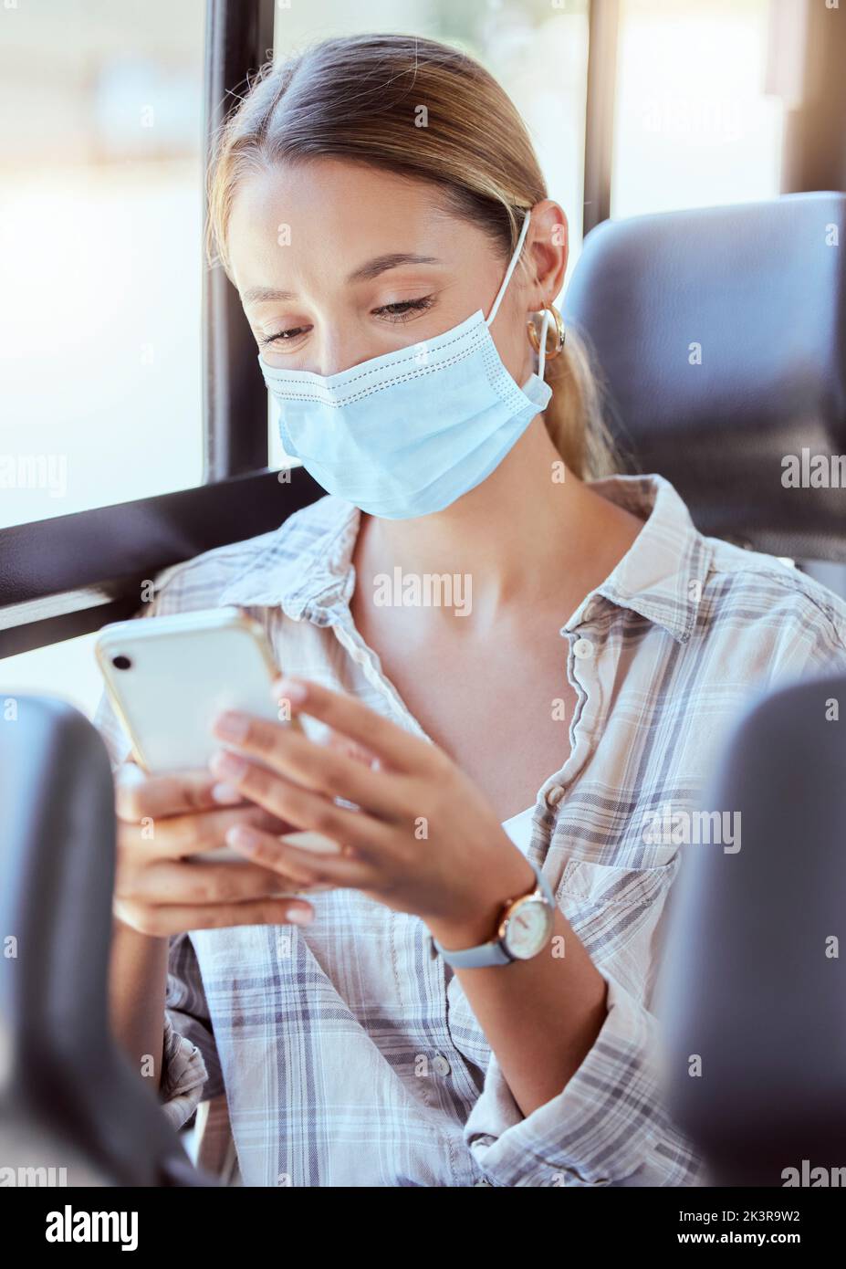 Covid, phone and bus with a woman in a mask using public transport to ...