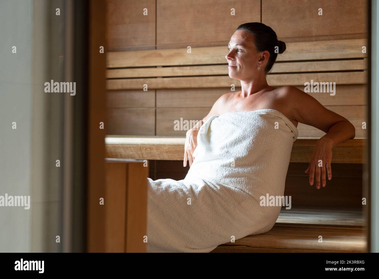 Senior woman sitting relaxed in a wooden sauna Stock Photo - Alamy