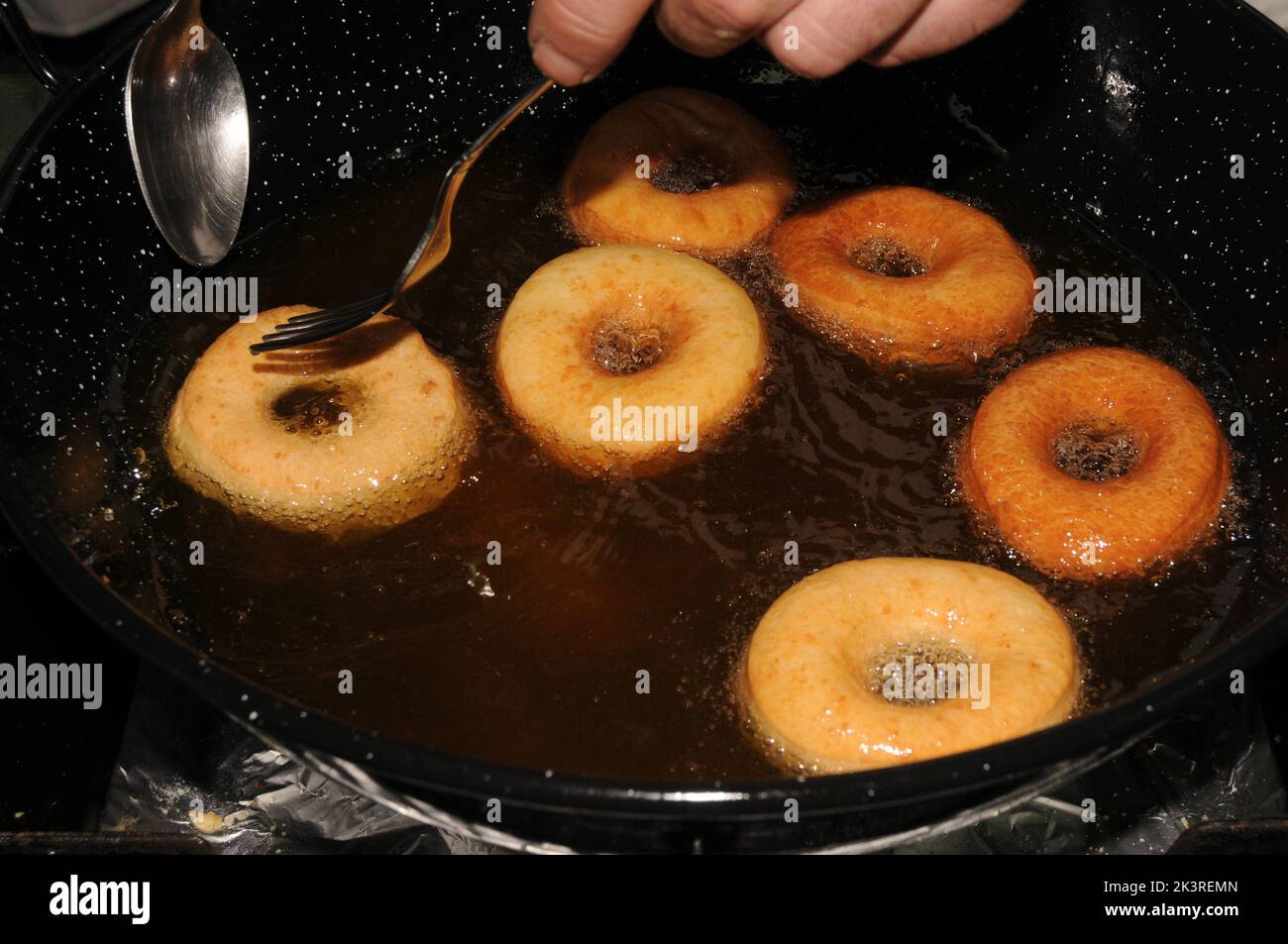 Donuts fried in light oil. Preparation of traditional donuts Stock ...